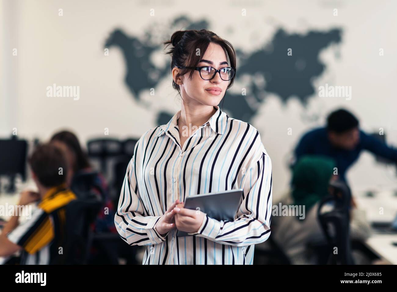 Portrait of businesswoman in casual clothes holding tablet computer at ...