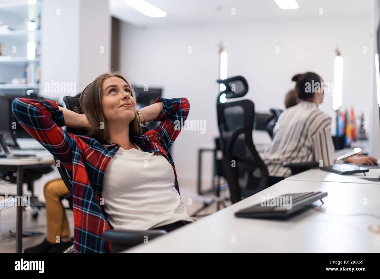 Casual business woman taking a break while working on desktop computer ...