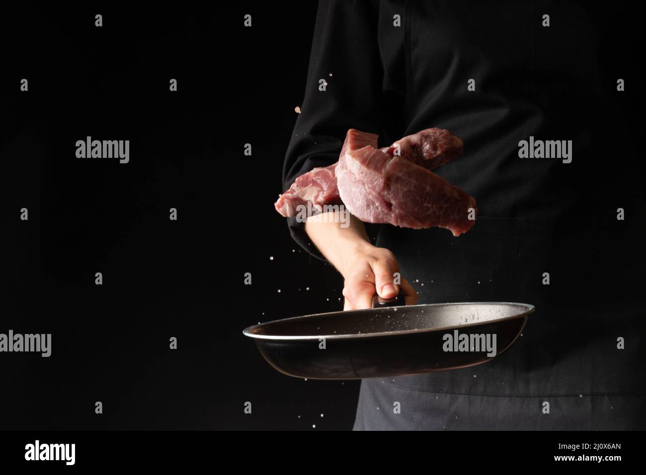 The chef prepares steaks from meat, pork or beef, throwing fresh meat ...