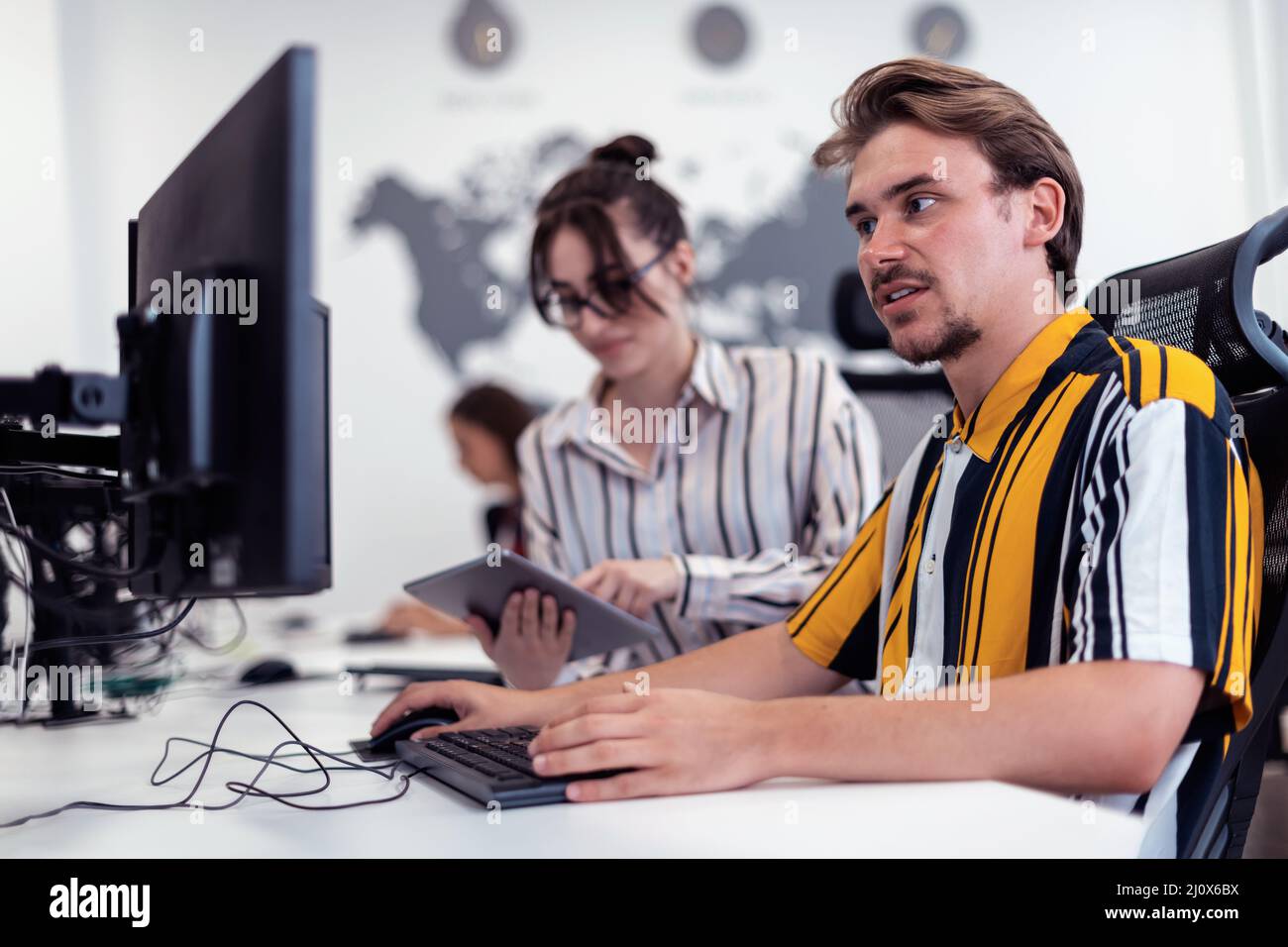 Business couple working together on project using tablet and desktop ...