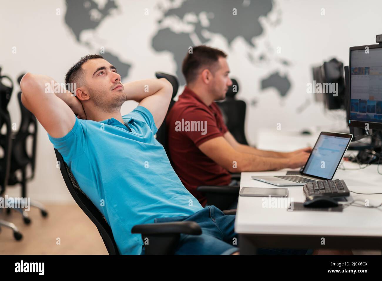 A time for relax. Young tired casual businessman relaxing at the desk ...