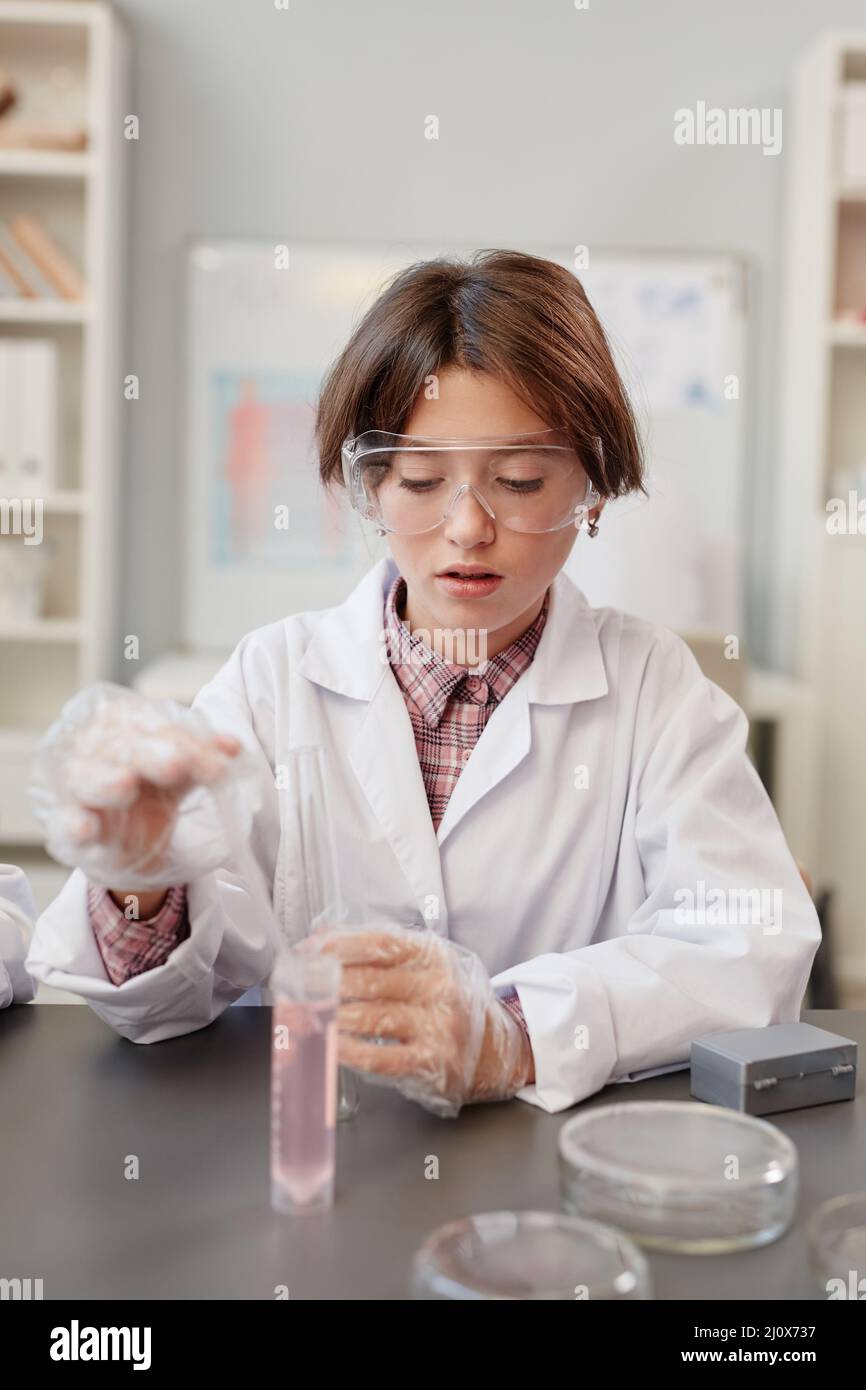 Vertican portrait of cute girl enjoying enjoying science experiments in ...