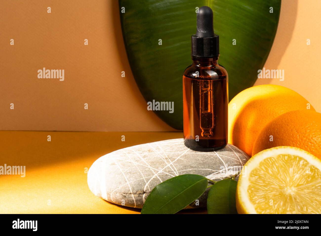Vitamin C serum in a glass bottle, orange background. Organic SPA ...