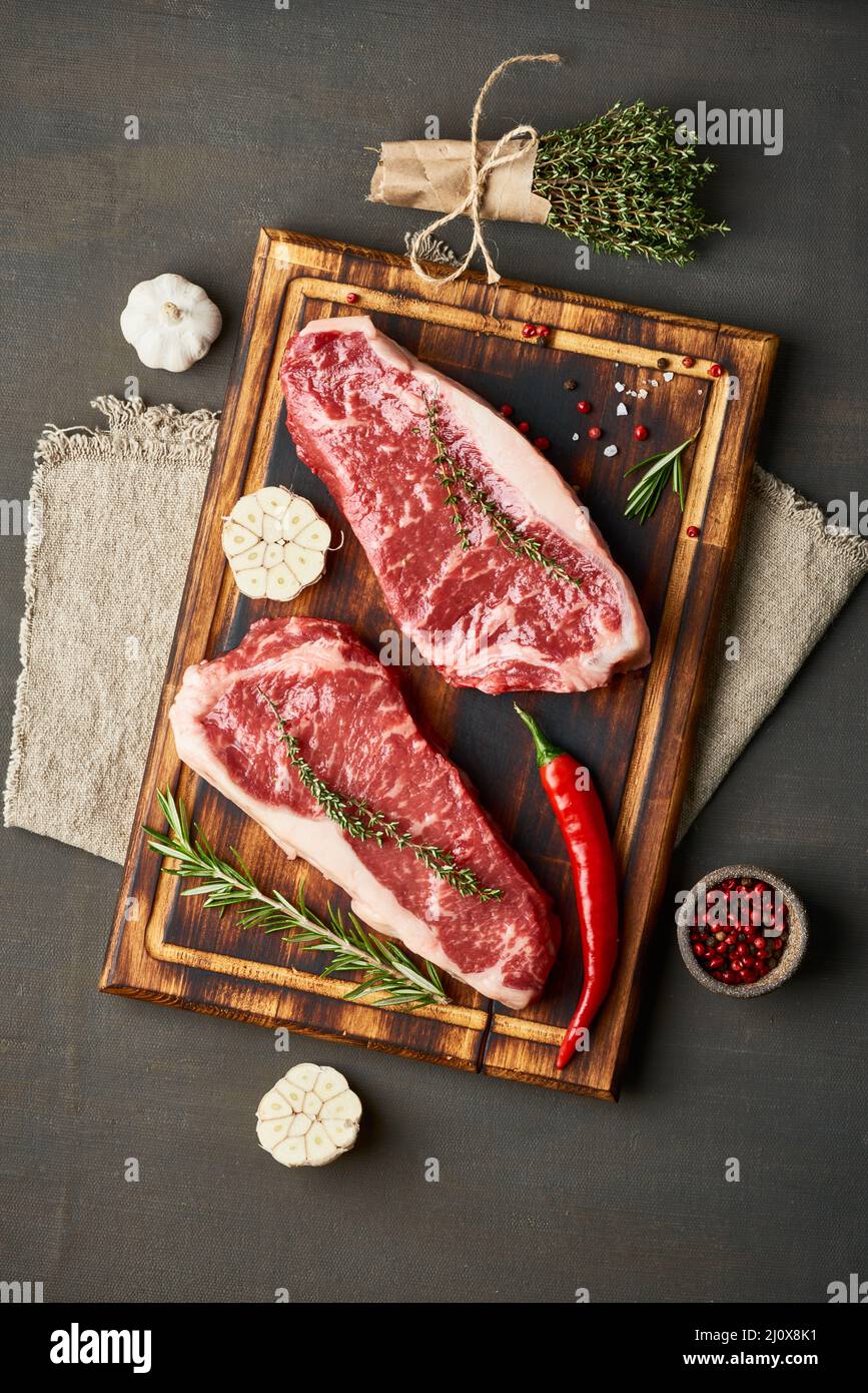 Big whole piece of raw beef meat. Seasoning steak with salt, thyme ...