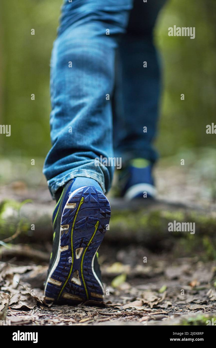 On the trail. Shot of an unidentifiable young man hiking through the ...