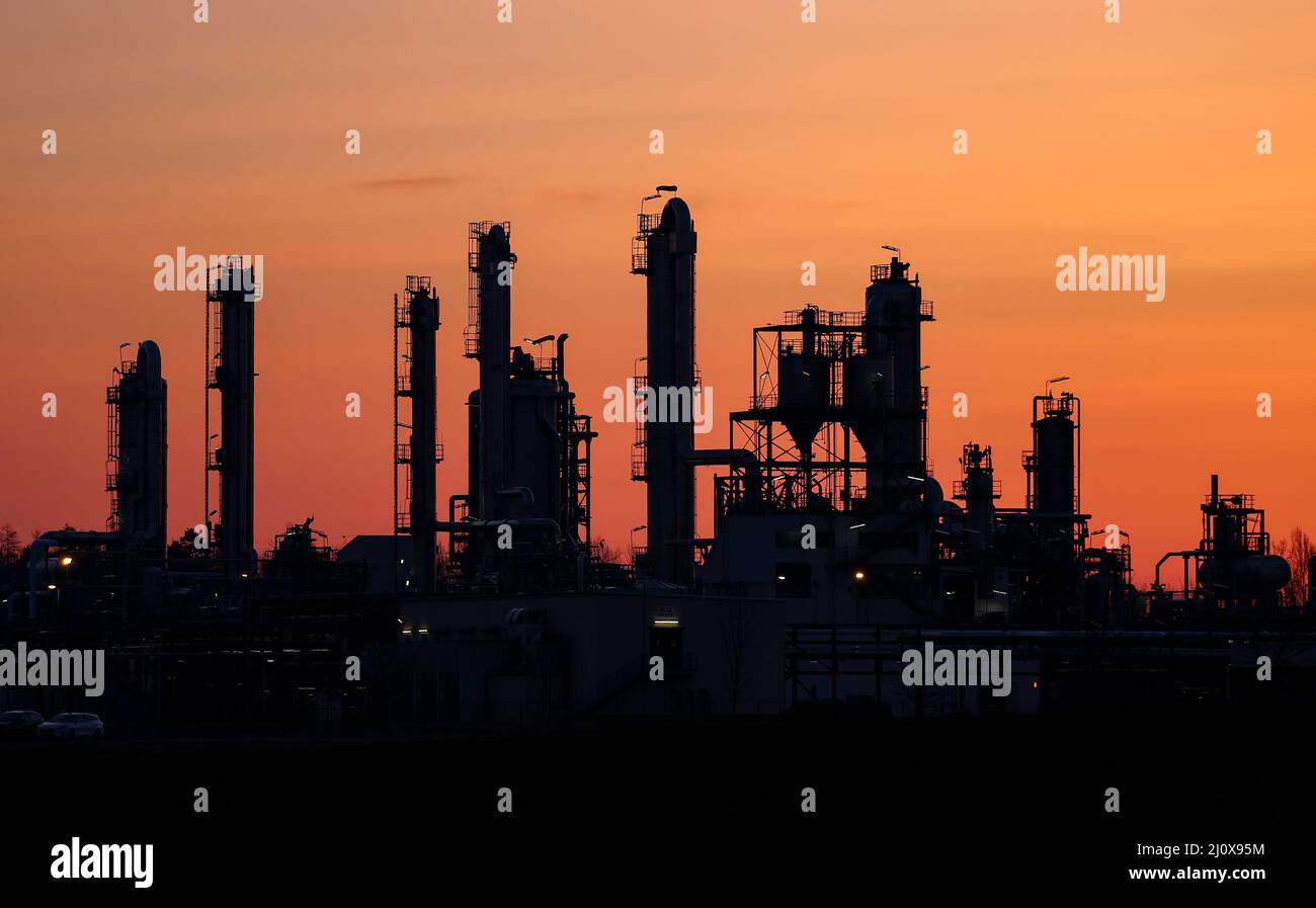 21 March 2022, Saxony, Böhlen: The morning sun colors the sky behind ...
