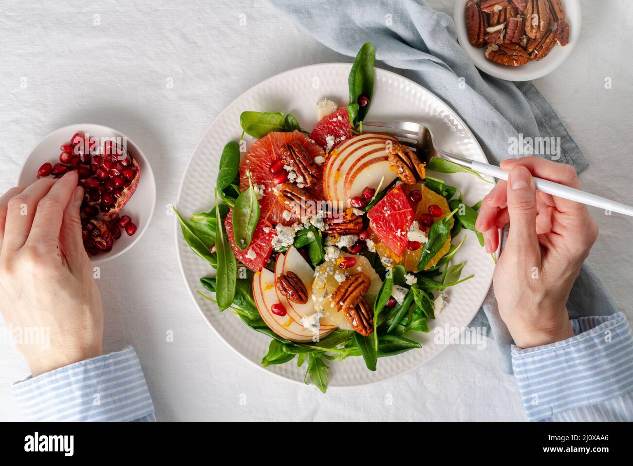 Woman eating Fruits citrus salad with nuts, green lettuce leaves ...