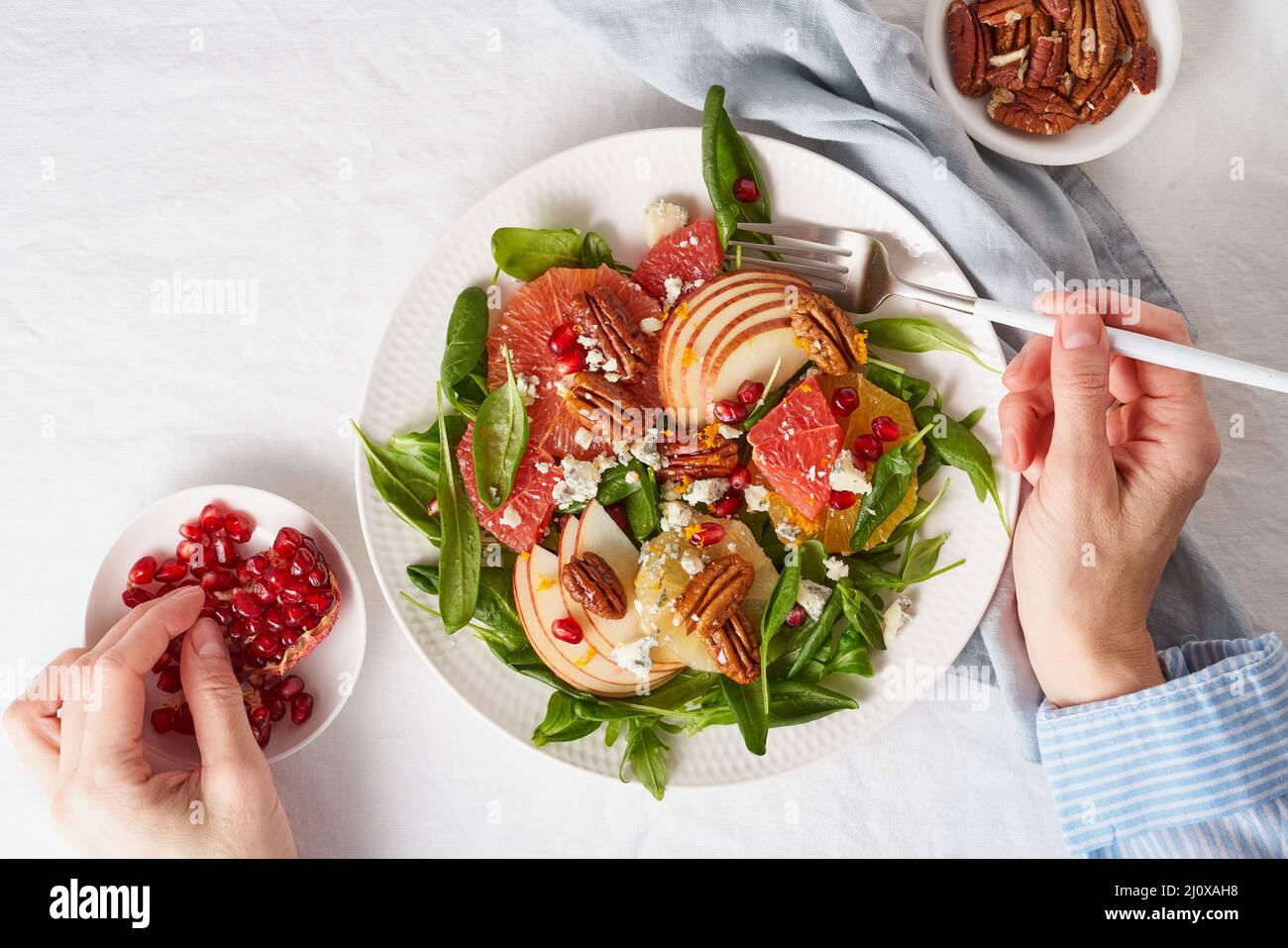 Woman eating Fruits citrus salad with nuts, green lettuce leaves ...