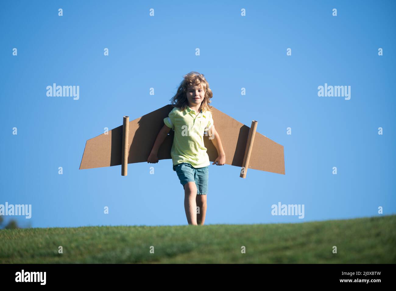 Kids fly. Funny child boy pilot flying with toy cardboard airplane ...