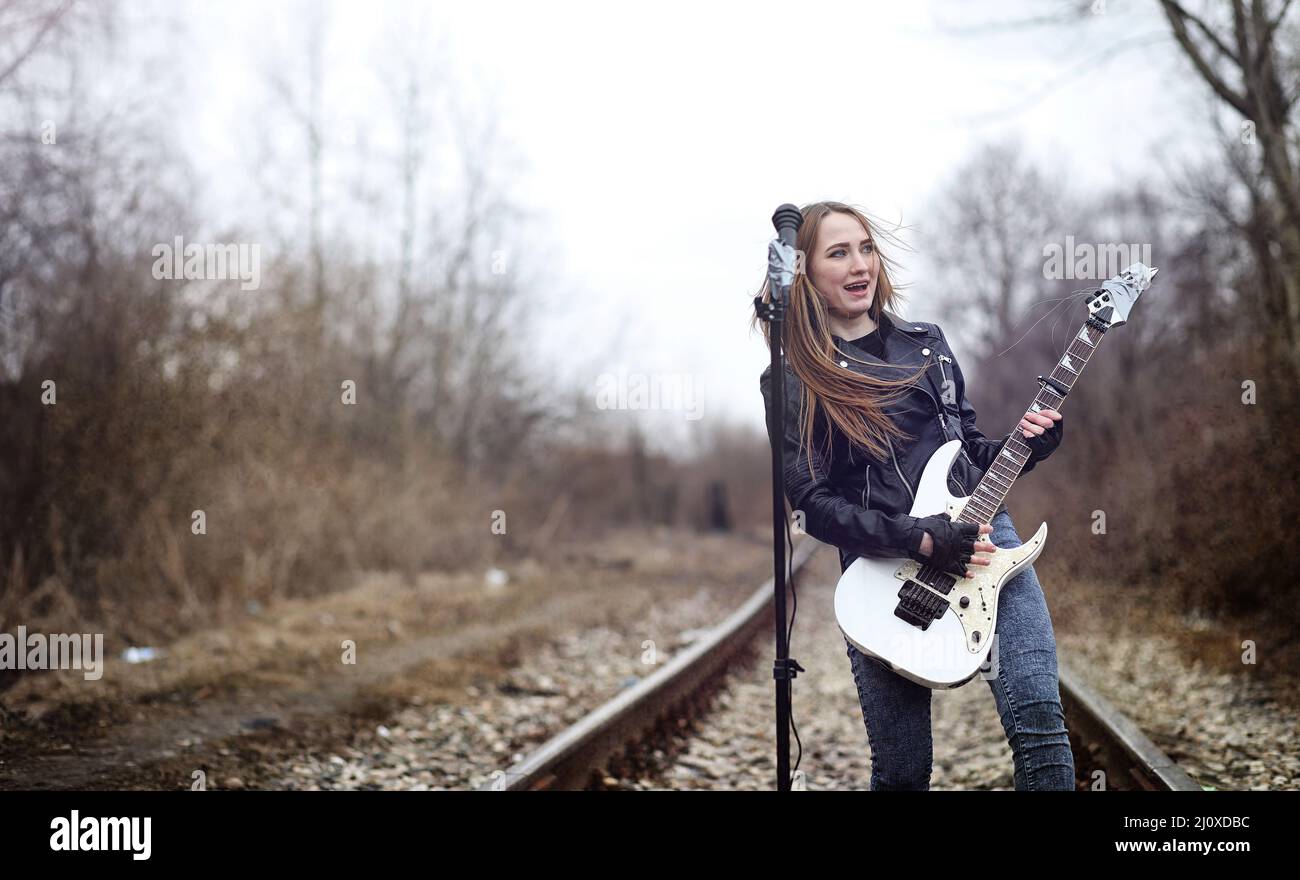 Beautiful young girl rocker with electric guitar. A rock musician girl ...