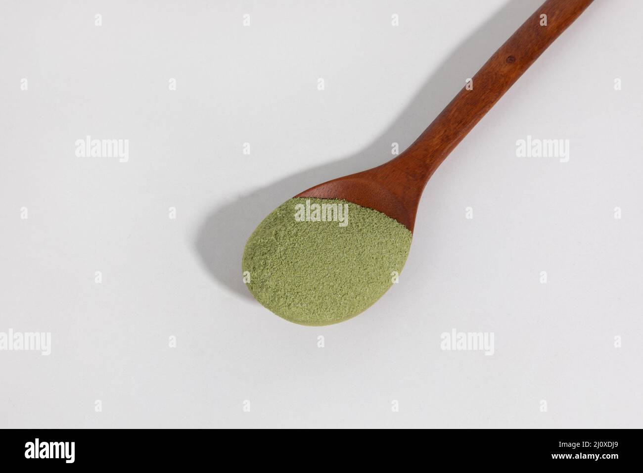 Matcha green tea powder and spoon in white background Stock Photo - Alamy