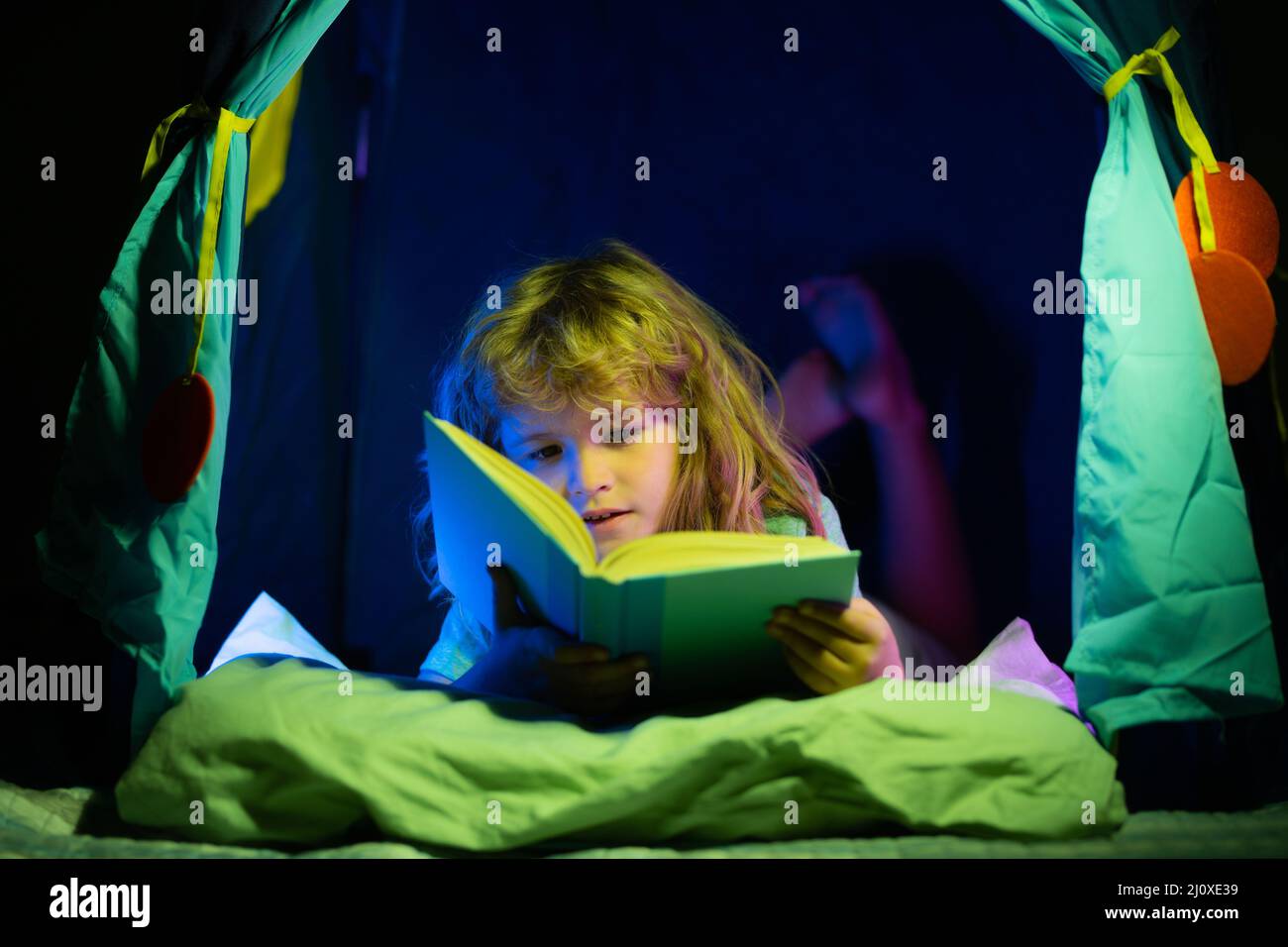 Kids reading books. Little boy in kids tentat home watching pictures in ...