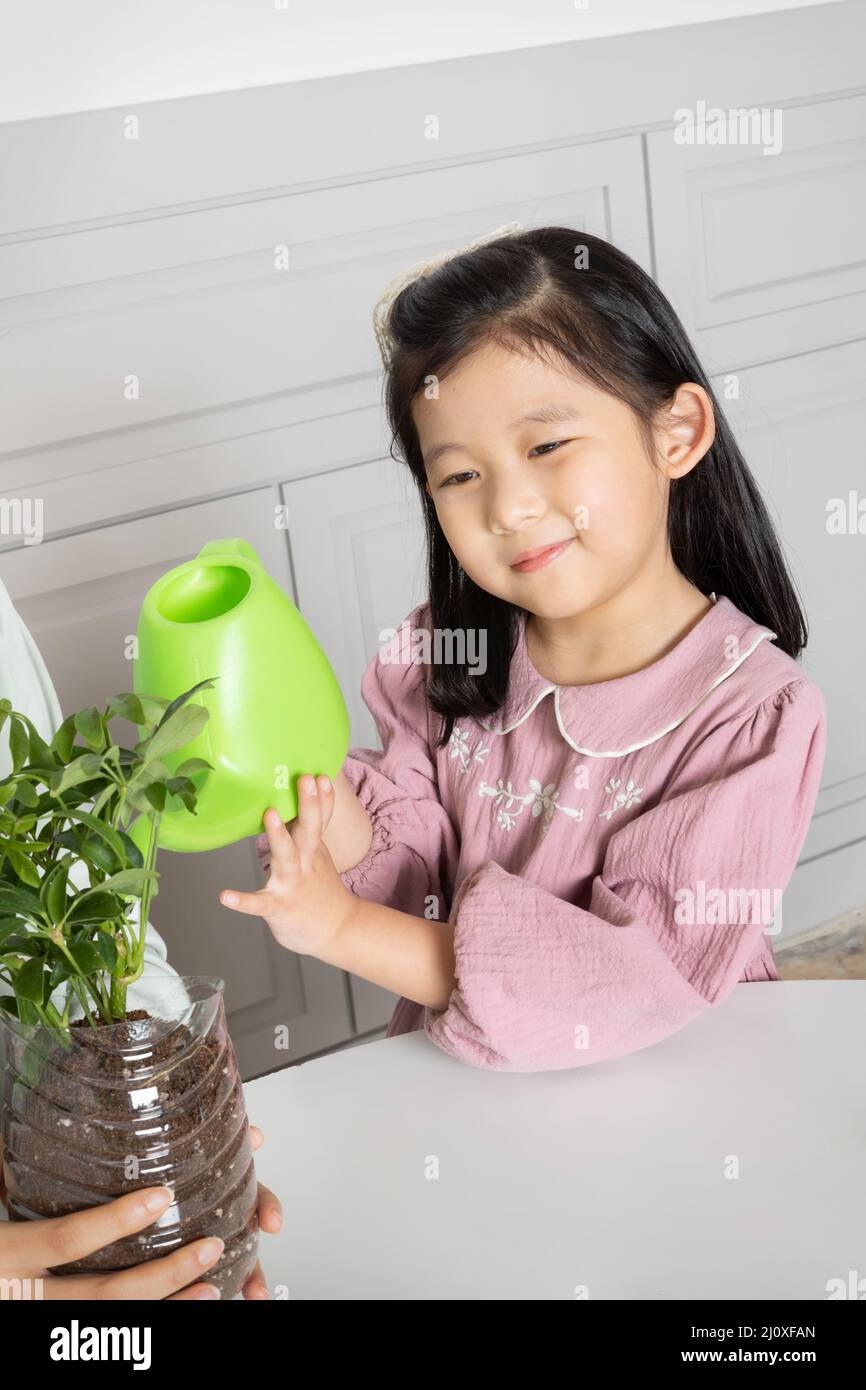 Mom and daughter watering plant hi-res stock photography and images - Alamy