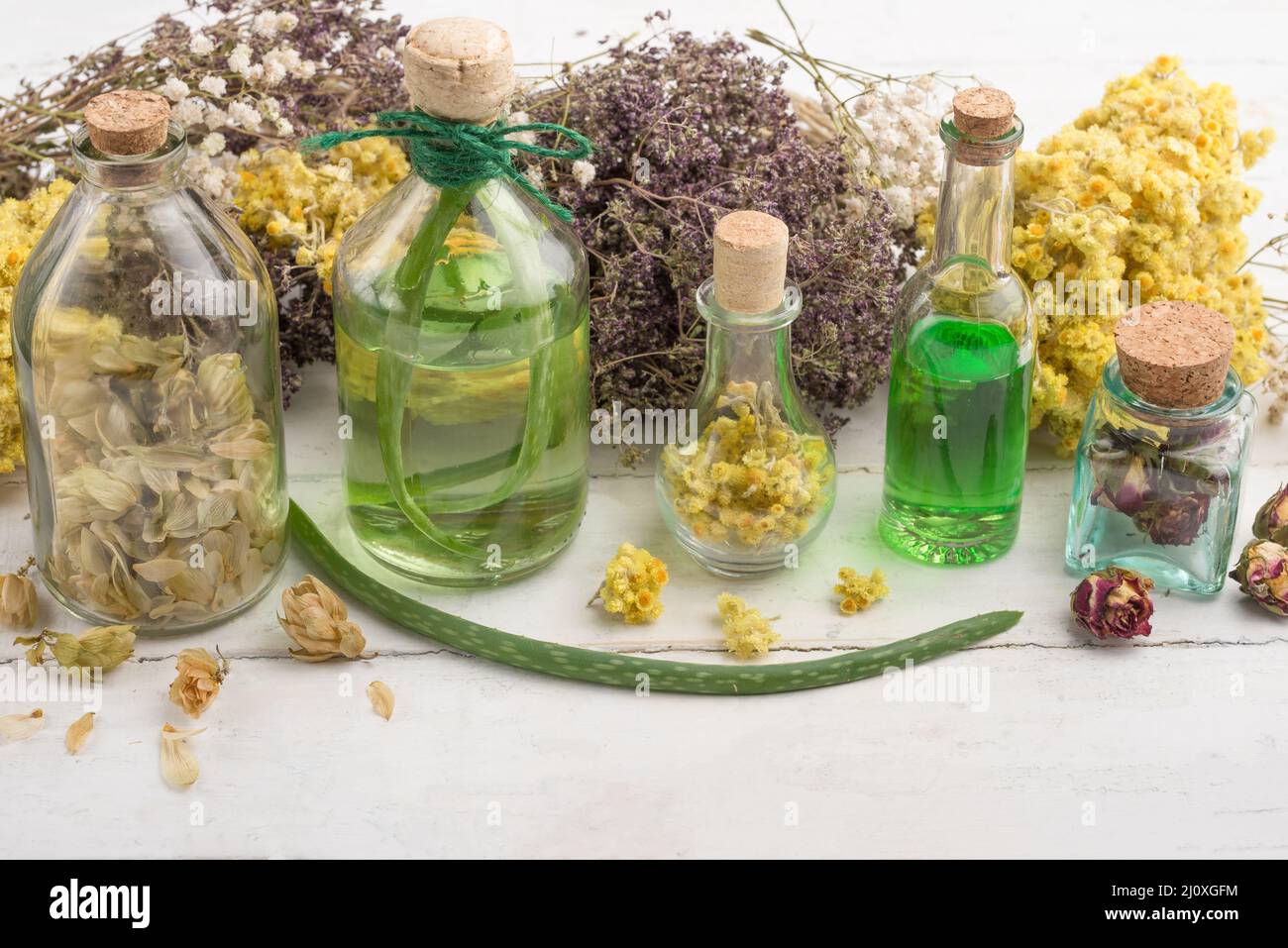 Aromatic oil, aromatic herbs in glass bottles, on a wooden background ...