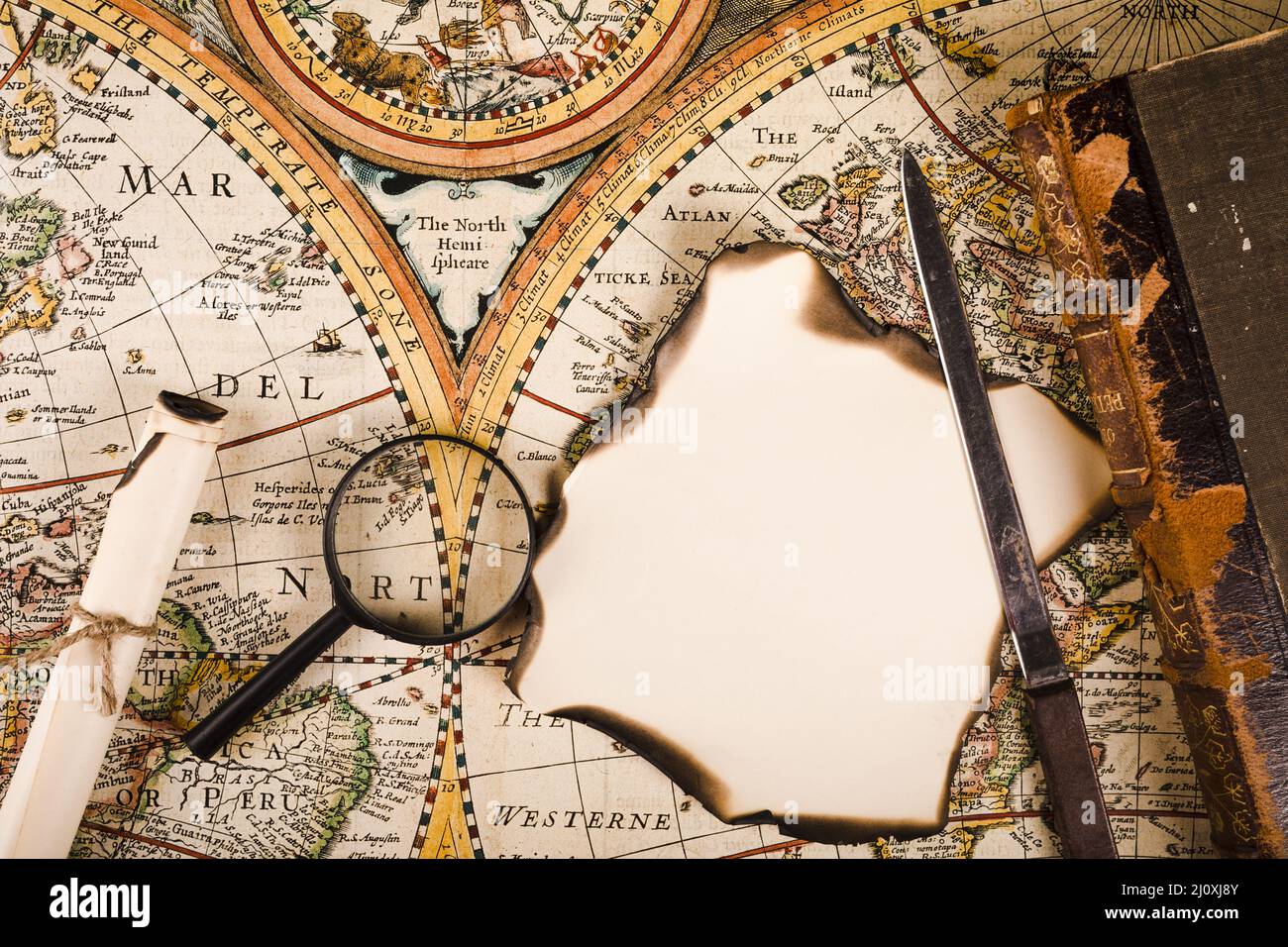 Elevated view magnifying glass burnt paper knife map. High quality ...