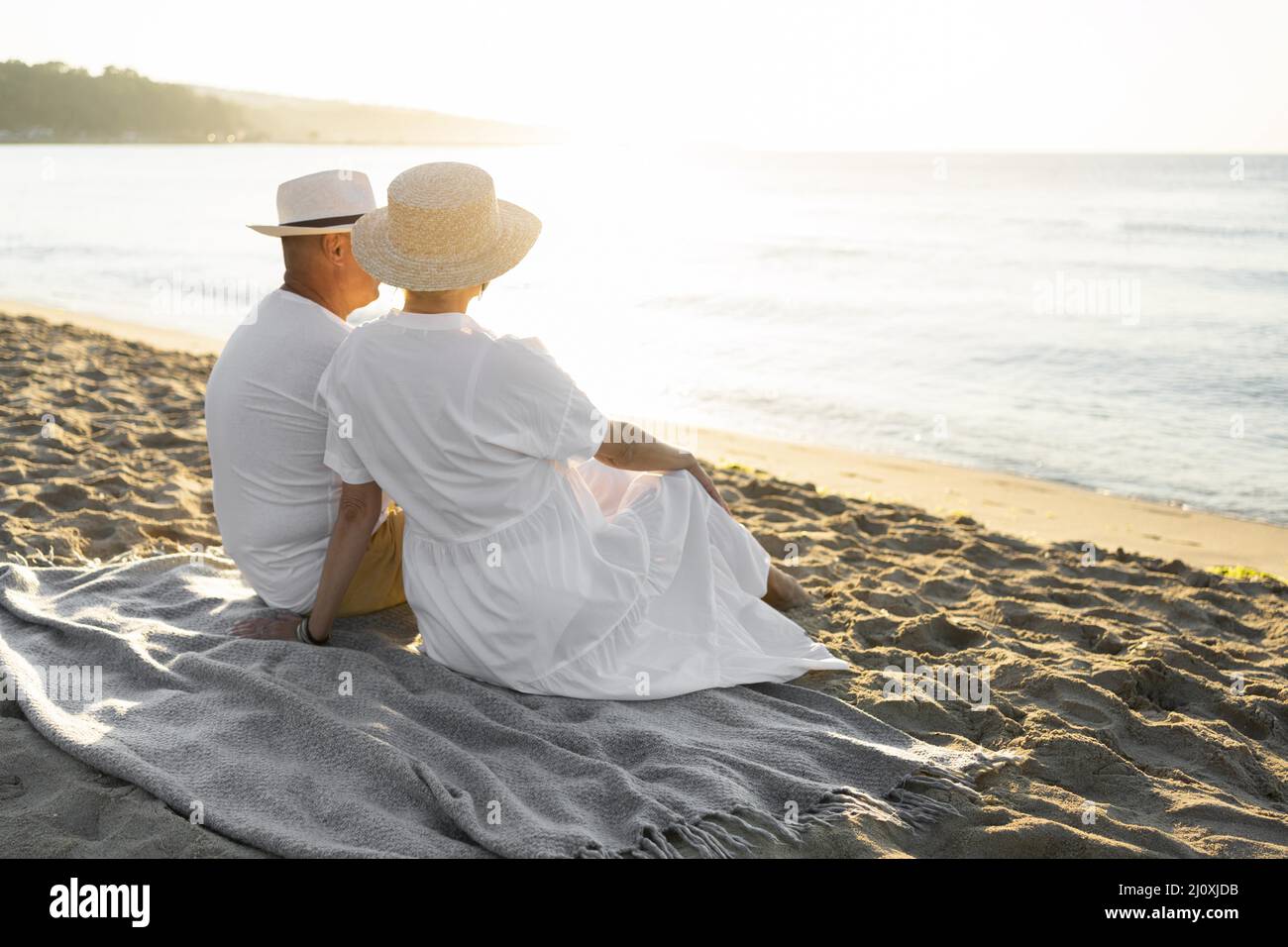 Full shot couple sitting blanket. High quality photo Stock Photo - Alamy
