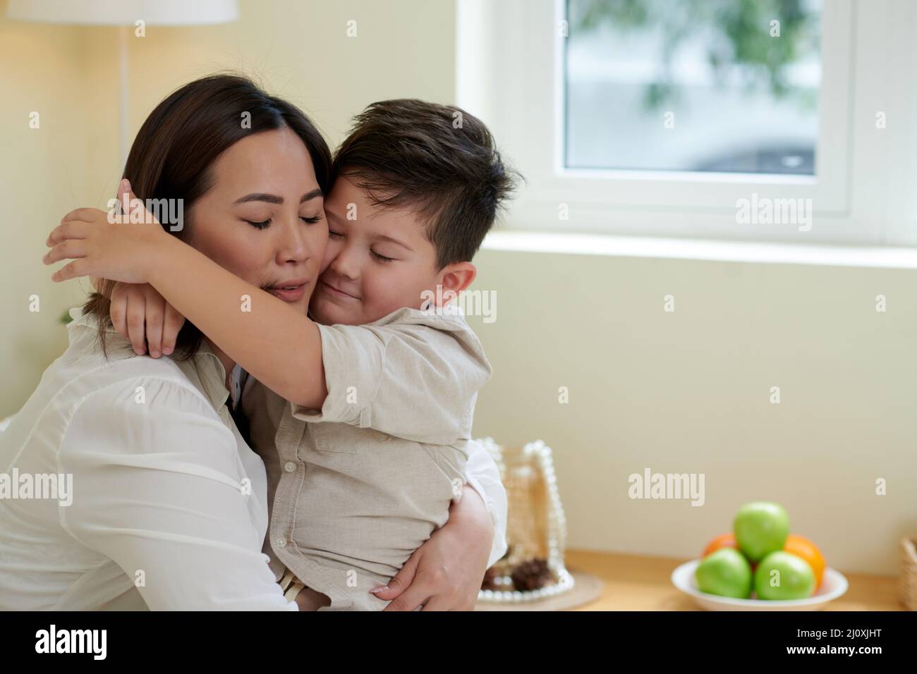 Mother closing eyes and bresthing out with relief when hugging little ...