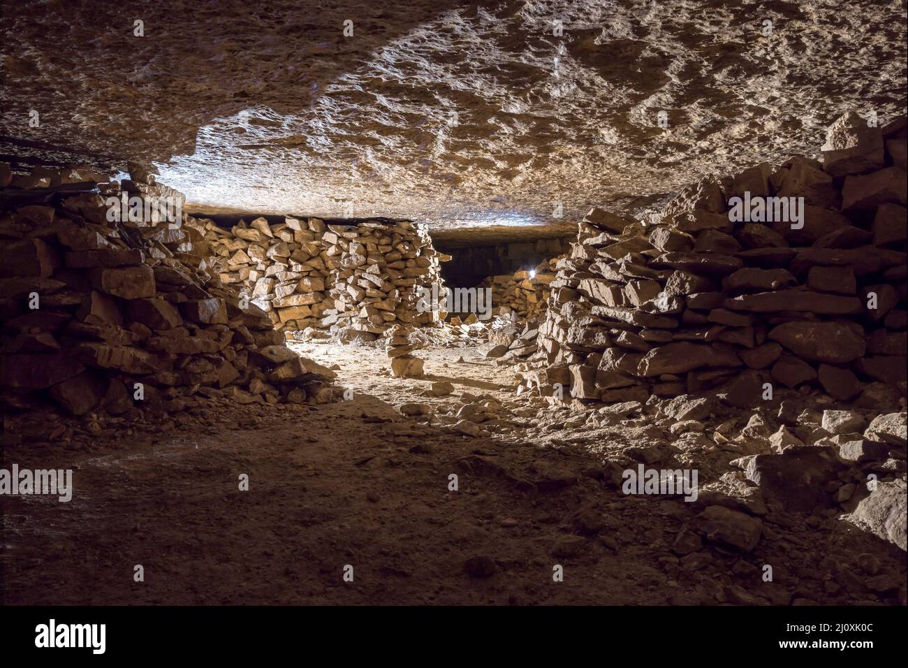 A gallery of abandoned limestone mine illuminated by counter light ...