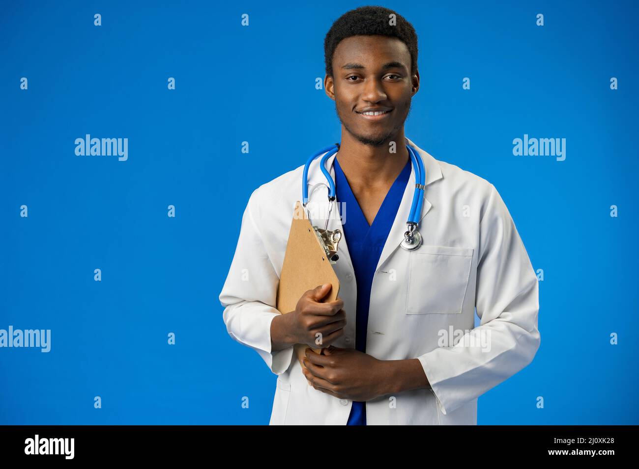 Confident black doctor posing over blue studio background Stock Photo ...