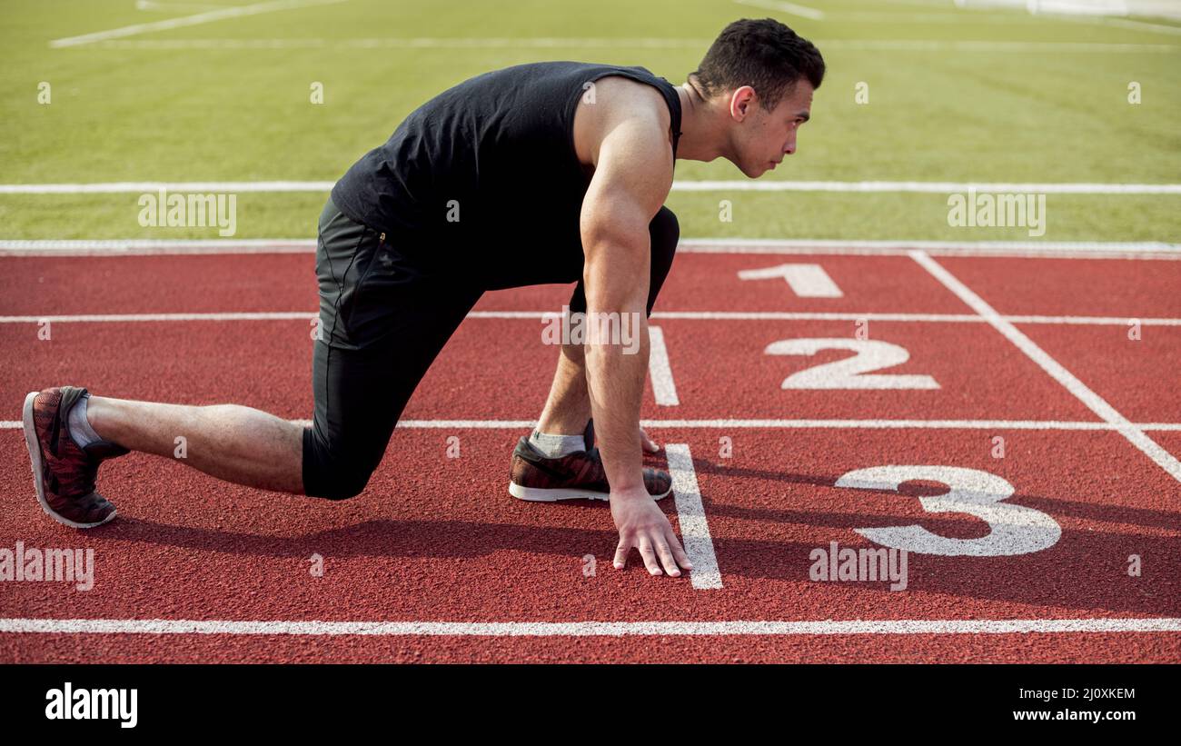 Side view male runner sprinter getting ready start race. High quality ...