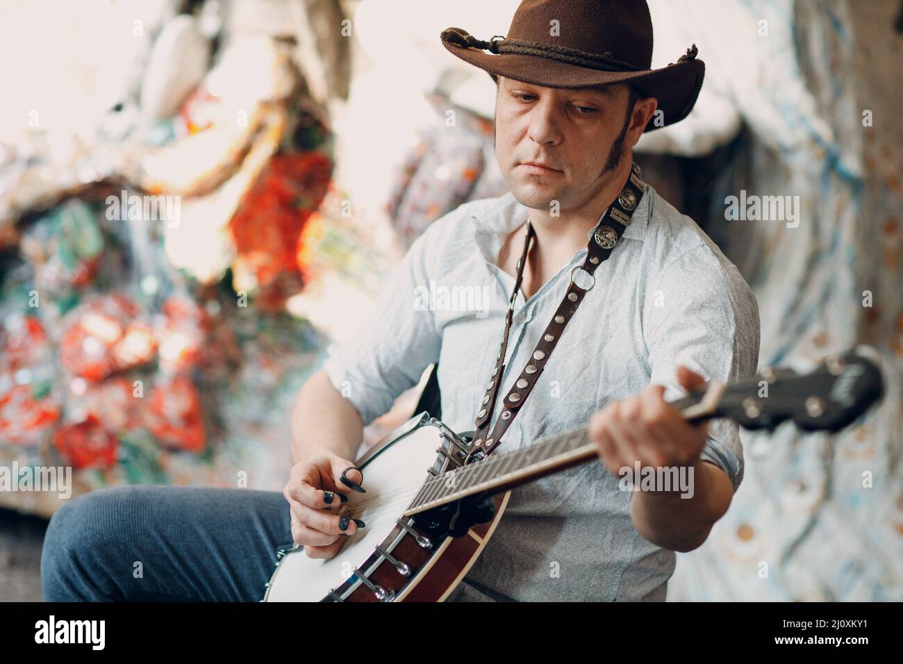 Male musician playing banjo sitting chair indoor Stock Photo - Alamy