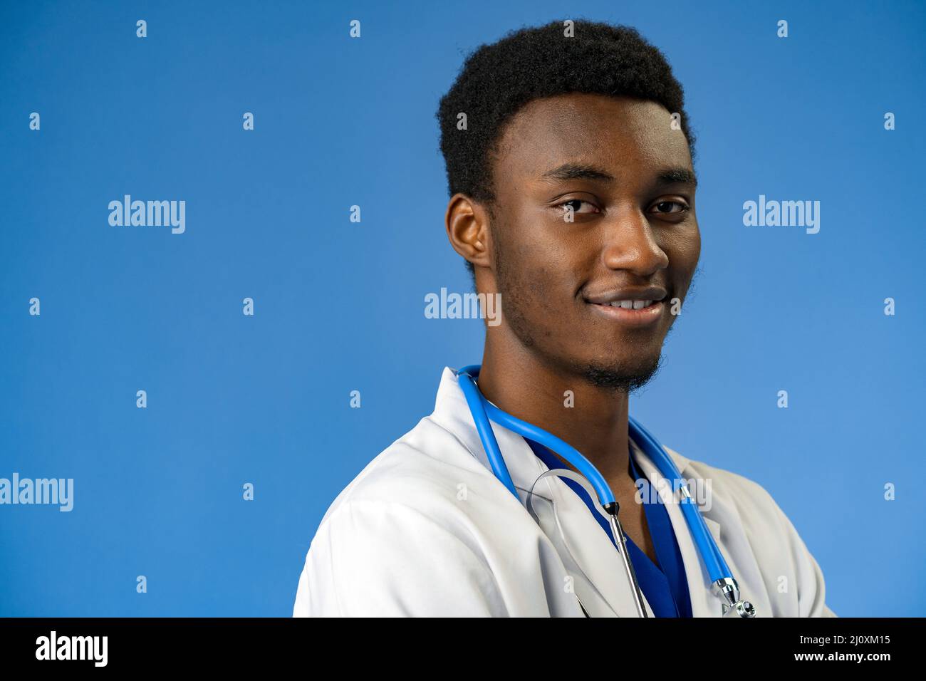Confident black doctor posing over blue studio background Stock Photo ...