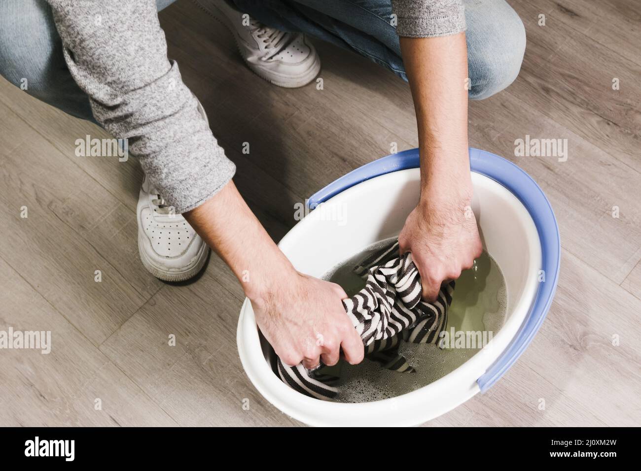Close up man squeezing wet cloth bucket Stock Photo - Alamy