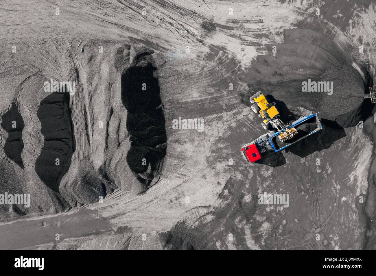 Industrial excavator loading stone, crushed stone or sand into truck ...