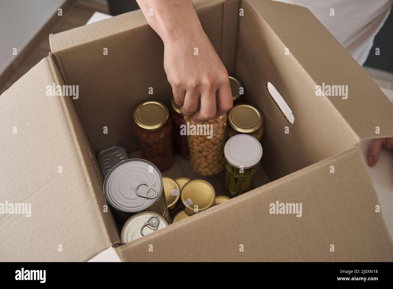 Unrecognizable man filling donation box with non-perishable food Stock ...