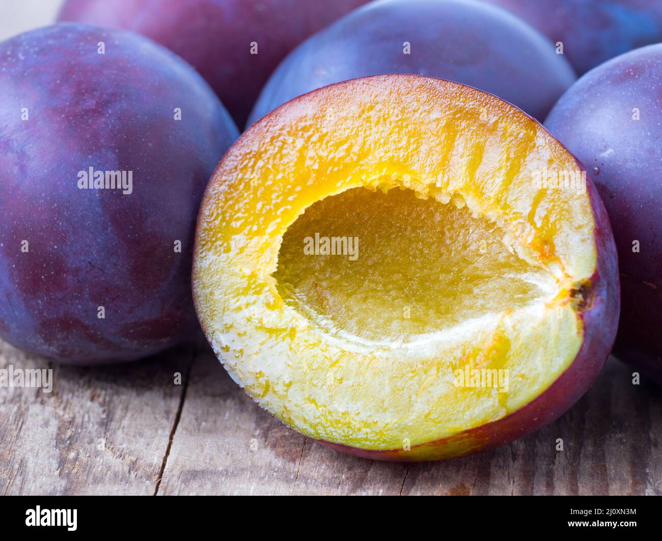 Large red sweet plum and cut off half Stock Photo - Alamy