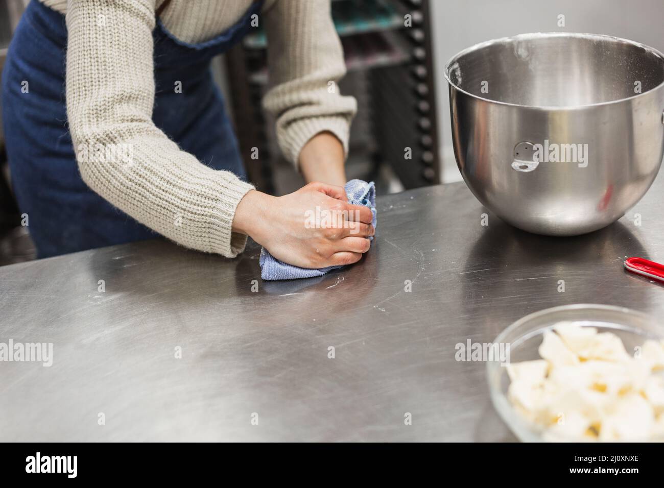 Woman cleaning work table where she is making pastry recipe in bakery ...