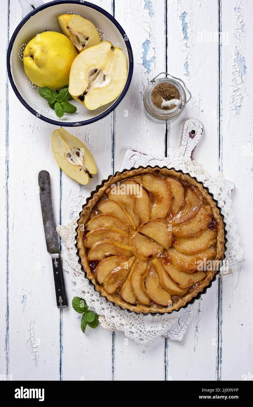 Traditional French quince tart aux pommes served as top view in classic ...