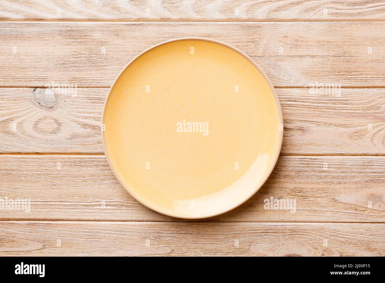 Top view of empty orange plate on wooden background. Empty space for ...