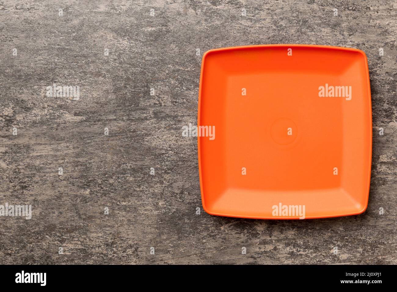 Top view of empty square plate on cement background. Empty space for ...