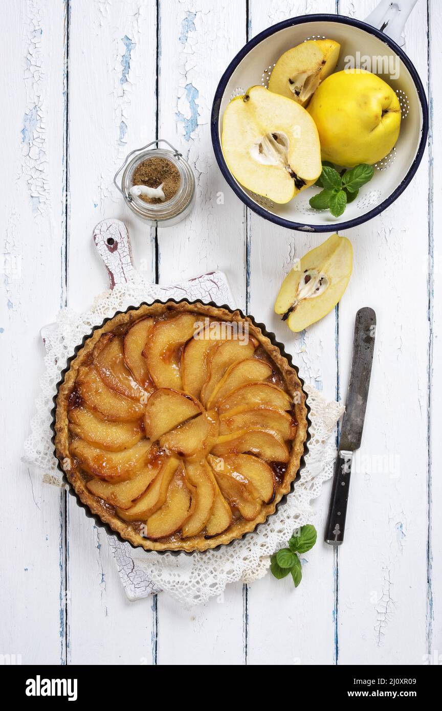 Traditional French quince tart aux pommes served as top view in classic ...