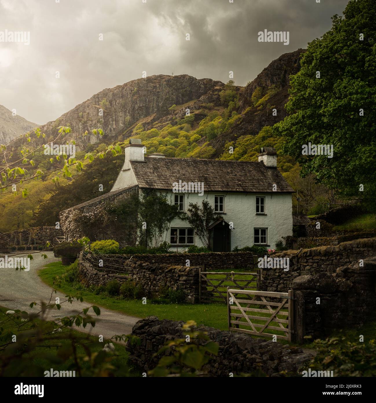 Beautiful white cottage in the middle of tall hills and green nature ...