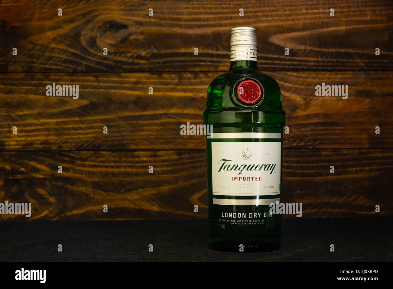 A bottle of English Tanqueray London Dry Gin on a dark wooden ...