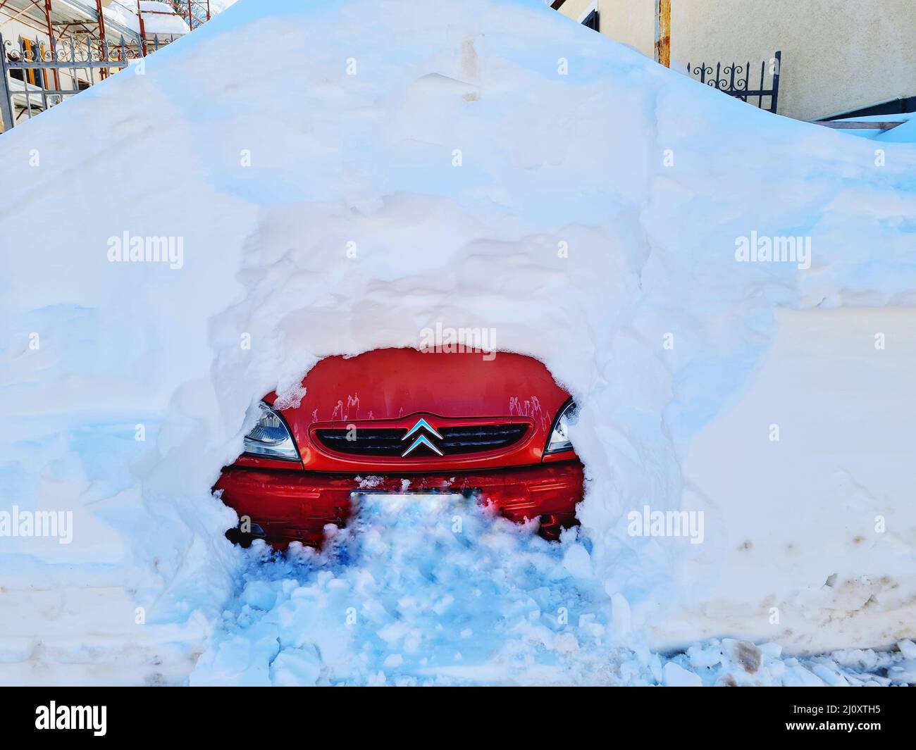 View of red car covered with a snowdrift Stock Photo - Alamy