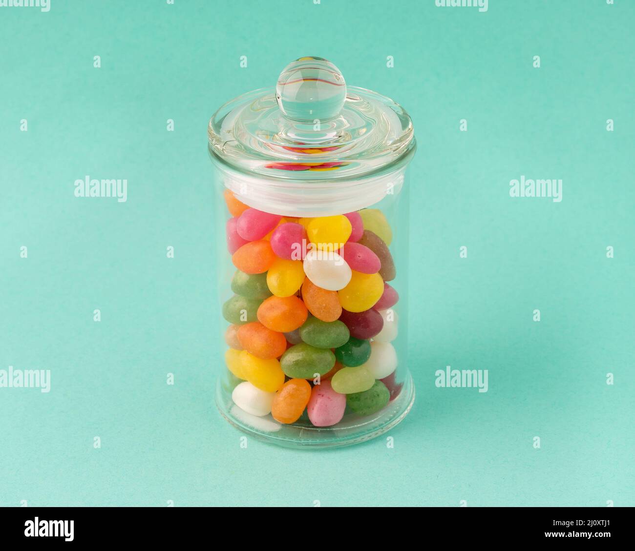 Glass jar with sweets, candy on a turquoise background Stock Photo - Alamy