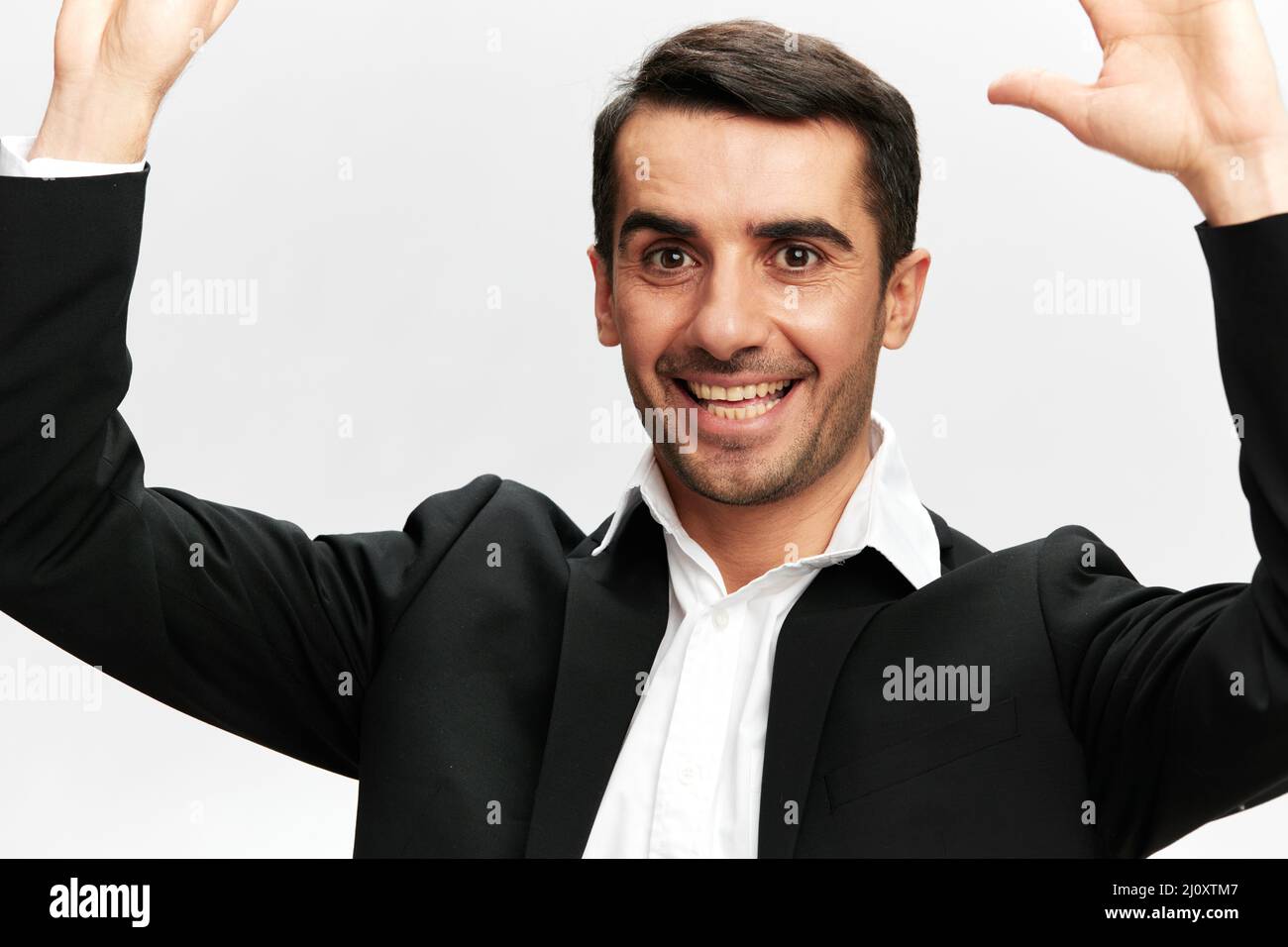 smiling man in business suit holding hands above head close up isolated ...