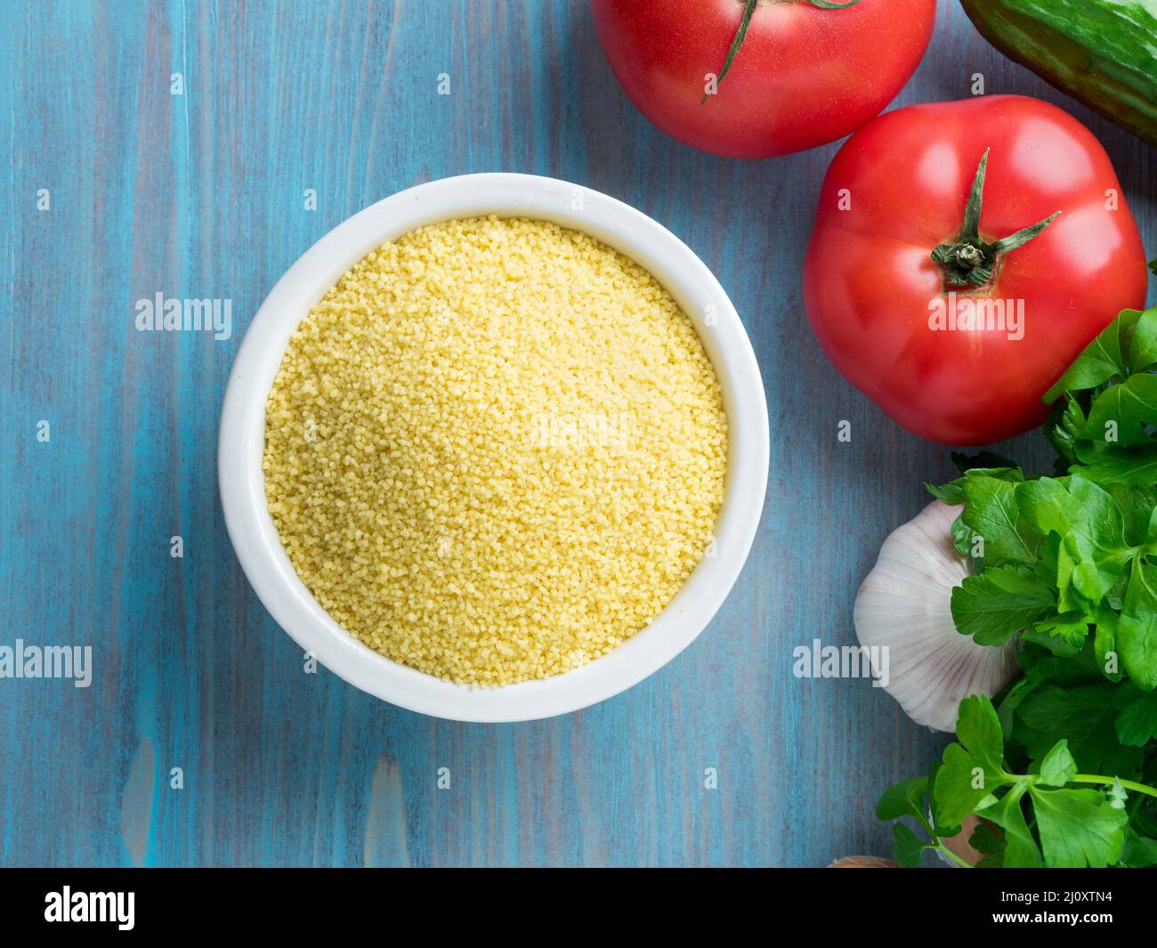 Vegetarian food - wheat, grain of raw couscous in a white bowl on a ...