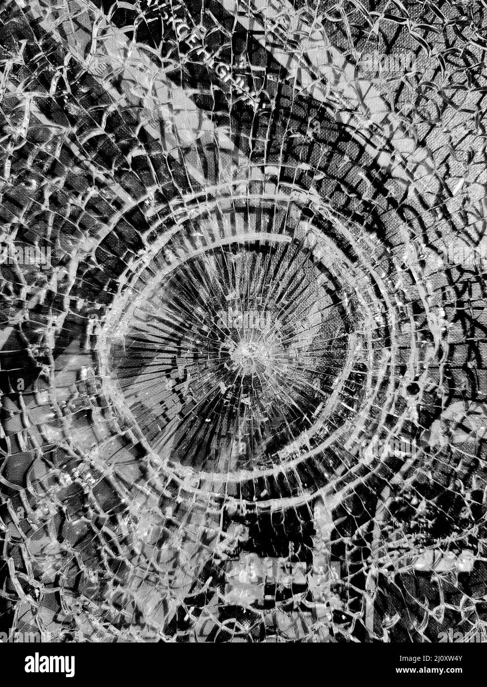 Broken glass. Round hole with radial cracks in the glass. Round white ...