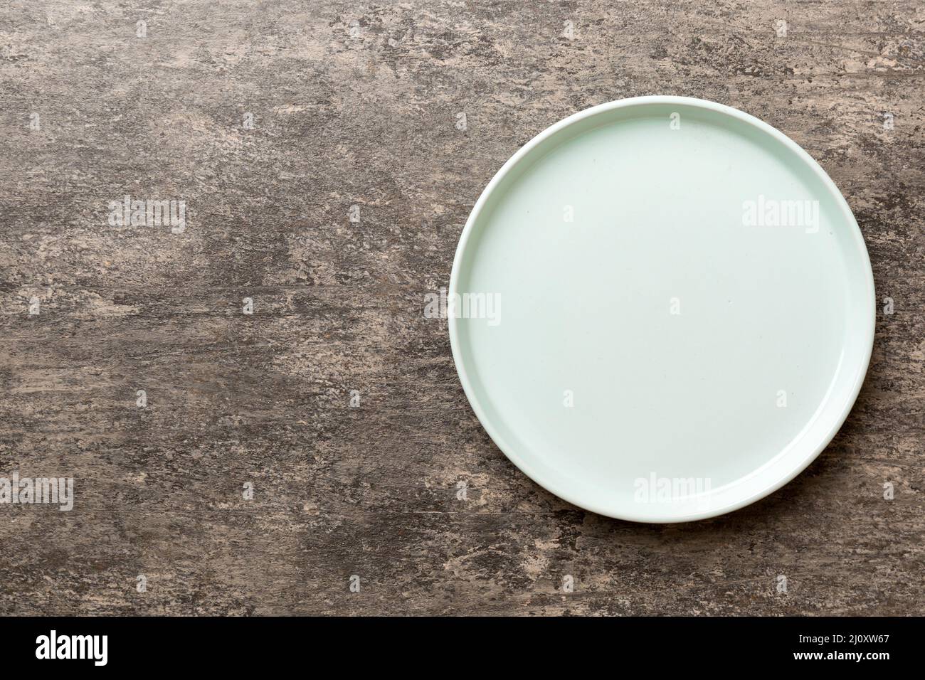 Top view of empty green plate on cement background. Empty space for ...