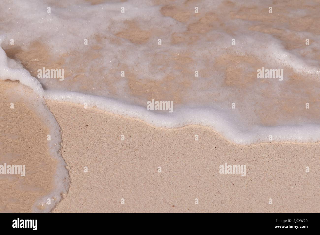 Bubbles waves and sand on the beach texture background Stock Photo - Alamy
