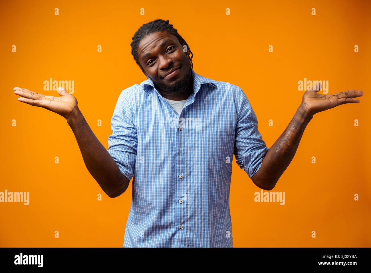 Young afrcian man isolated on yellow background showing helpless ...