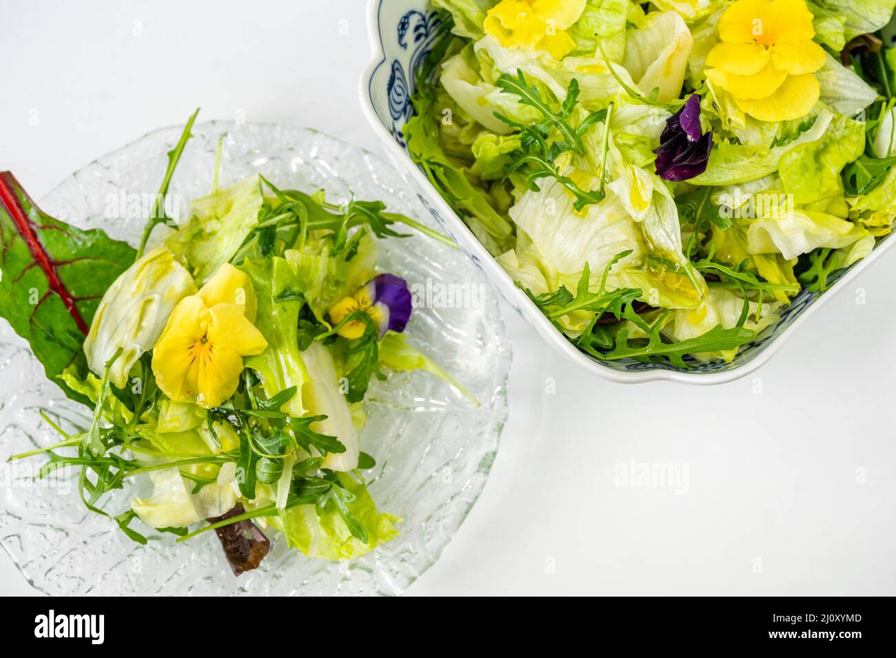 Fresh green salad (lettuce,rucola,red chard) with edible pansy flower ...
