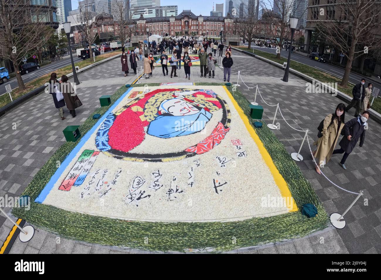 Tokyo, Japan. 21st Mar, 2022. Visitors look at a huge kabuki actor ...