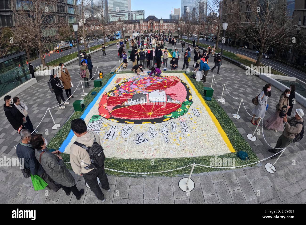 Tokyo, Japan. 21st Mar, 2022. Visitors look at a huge kabuki actor ...