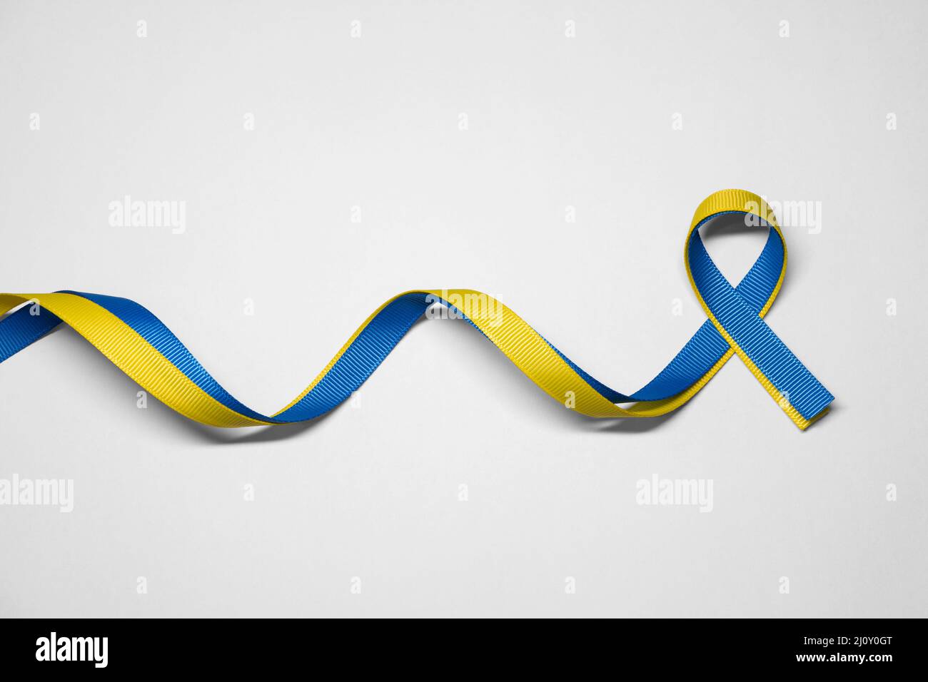 Blue and yellow ribbon for Ukraine on white background with clipping ...