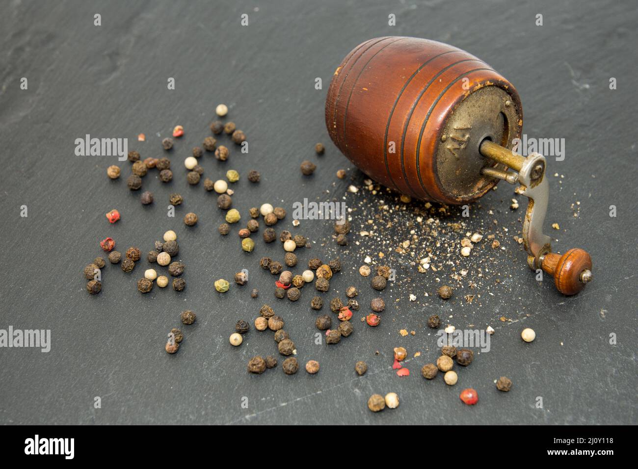 old pepper grinder and assorted pepper whole grains and ground pepper ...